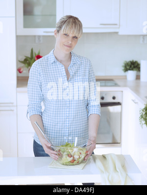 Young woman making salad at domestic kitchen Stock Photo - Alamy
