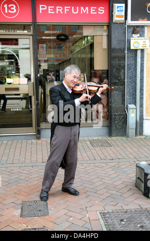 Chinese busker with gray hair playing violin in Hertford Market ...