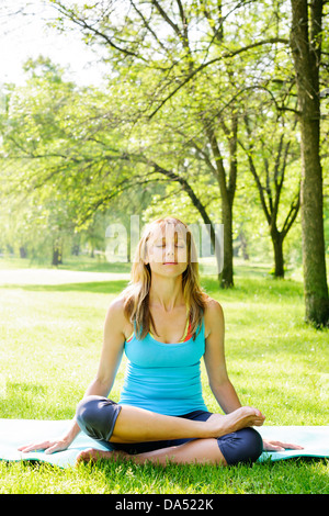 Meditation yoga woman in spring park. Woman doing stretching up ...