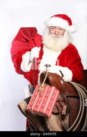 Santa Claus standing next to a western saddle and presents Stock Photo ...