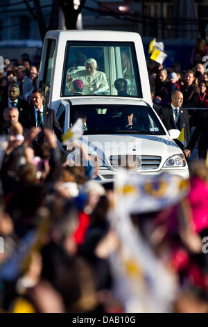 Pope Benedict XVI drives trough the faithful in his Papamobil during ...