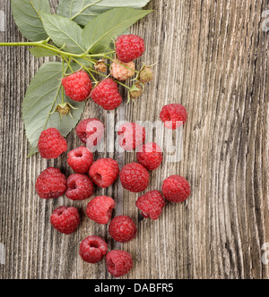 Raspberries With Leaves On The Rusty Wooden Table Stock Photo - Alamy