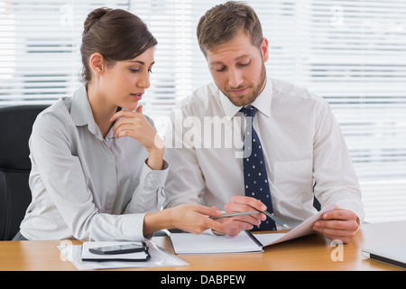 A business man and woman going over work documents In a binder Stock ...