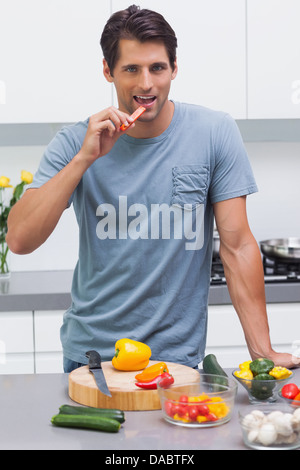 Male eating a slice of bell pepper Stock Photo - Alamy