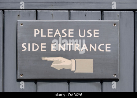 door sign stating please use side entrance Stock Photo - Alamy
