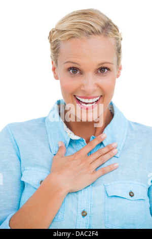 Shocked blonde woman looking at camera while covering face isolated on ...
