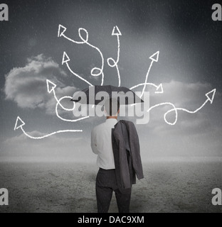 Serious businessman holding arrow and looking straight ahead on grey ...