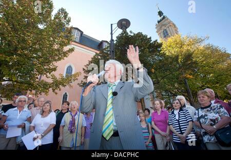 Choir leader Gotthilf Fischer (C) stands surrounded by a crowd singing ...