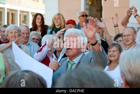 Choir leader Gotthilf Fischer (C) stands surrounded by a crowd singing ...
