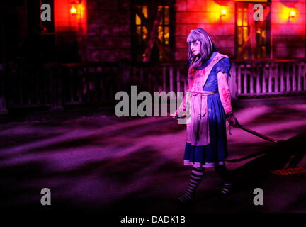 A performer costumed as 'evil Alice' scares visitors of the MoviePark ...