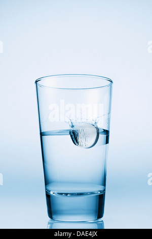 Tablet falling in glass of water Stock Photo - Alamy