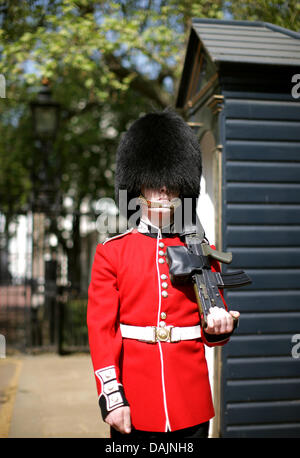 An officer of the Queen's royal guard patrols in front of Buckingham ...