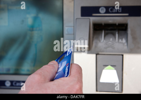 man operating atm cash machine withdrawing single ten pound note money ...