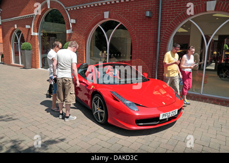 PEOPLE LOOKING AT A RED FERRARI SPORTS CAR DURING THE SHANGHAI AUTO ...