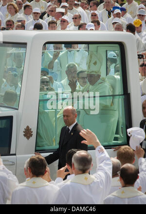 Pope Benedict XVI is driven through the crowd in his Popemobile prior ...