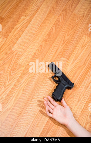 Woman lying on floor with gun Stock Photo: 21939643 - Alamy