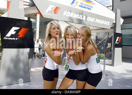 Three girls pose in the paddock before the start of the Formula One ...