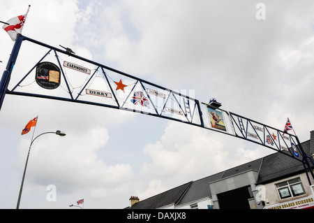 An Orange arch over a road in Kilkeel with flags, photographs of the ...