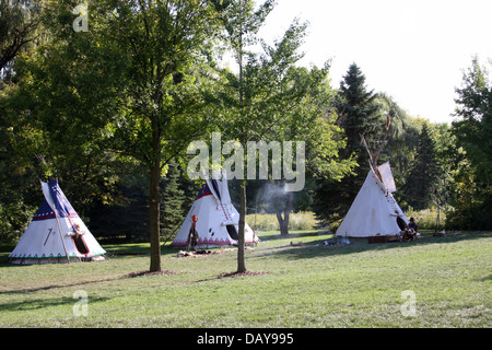 A Native American Indian tipi campsite with men playing the drum and ...