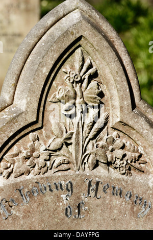 A gravestone bearing the inscription 'In Loving Memory' and 'In Sure ...