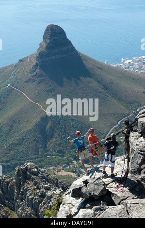 Abseiling on Table Mountain with the Lion's Head in the background ...
