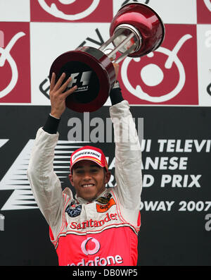 Mercedes driver Lewis Hamilton lifts the British Grand Prix Trophy as ...