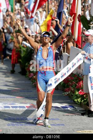 Australian triathlete Chris McCormack crosses the finish line with ...