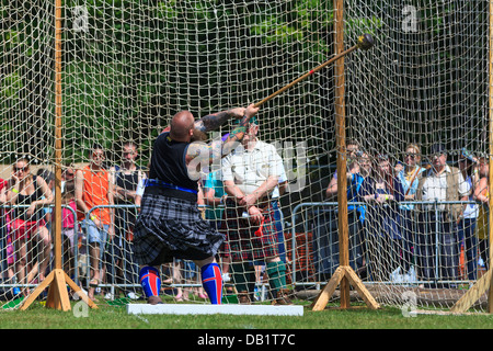 Competitor at Scottish highland games throwing the 22 pound hammer, a ...