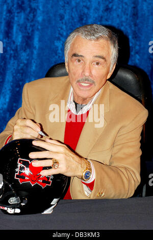 Burt Reynolds signs a football during a special appearance at Hollywood ...
