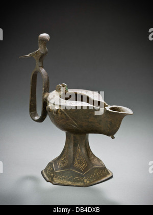 This oil lamp, crafted from ceramic, was historically used for lighting ...