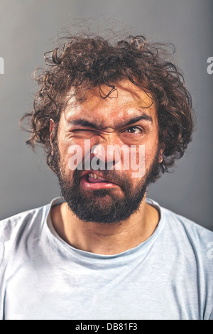 Guy squinting and making funny face eating sour lemon frowning and ...