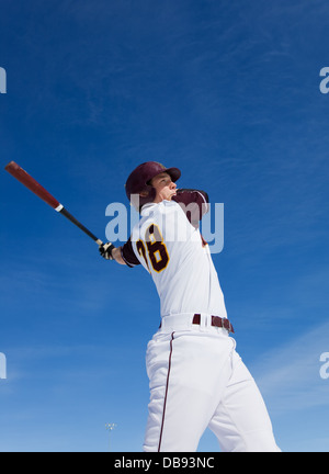Baseball player taking swing with bat on white background, back view ...