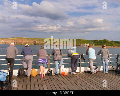 Men fishing from the end of Saltburn pier on the north east coast ...