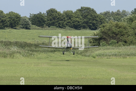 Biplane landing on the grass Stock Photo - Alamy
