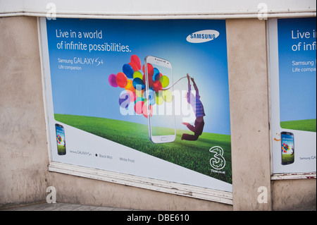 Samsung mobile phone advertising poster in shop window Stock Photo - Alamy