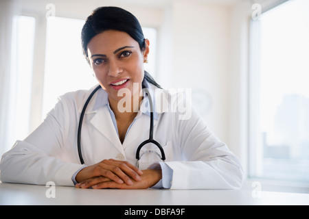 Happy Asian women doctor talking on mobile phone gesturing while ...