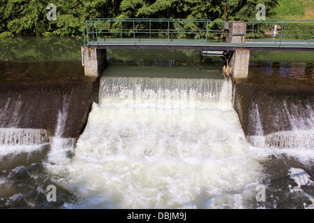 a dam retaining water from a swollen river with its bridge and ...