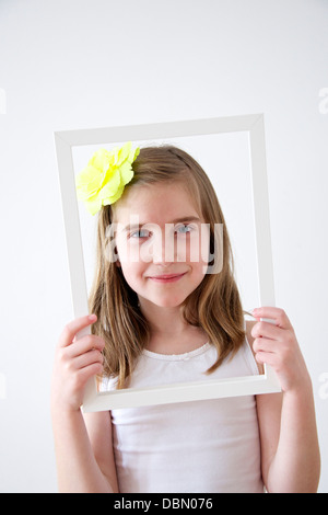 Girl looking through picture frame, having photograph taken Stock Photo ...