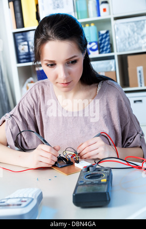 Electrician worker with tester measures the voltage in an electrical ...