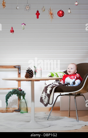 Cute Baby boy sitting in stainless steel pot colander in the kitchen ...