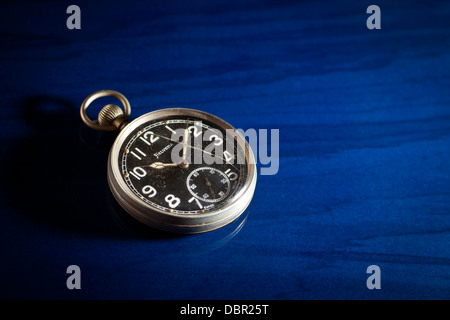 Old broken pocket watch on blue background Stock Photo - Alamy