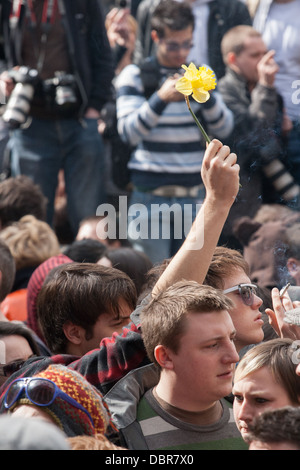 A protester holds up a flower in front of riot policemen during a ...