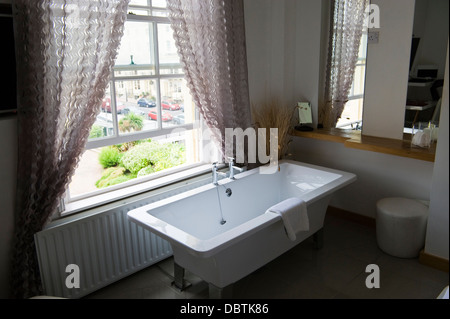 Bedroom of hotel with bath under window in Brighton East Sussex Stock ...