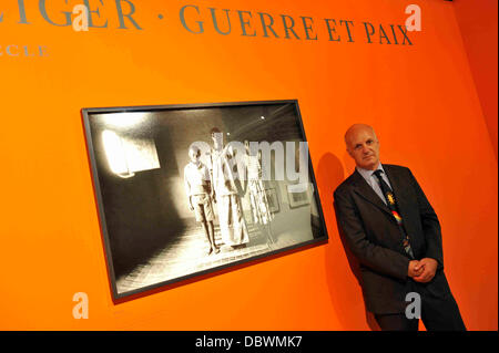 Nick Danziger poses in front of his photographs at his exhibition at ...