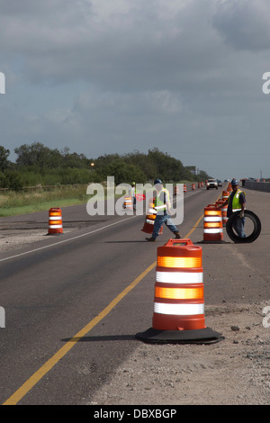 Falfurrias, Texas - Workers set out orange traffic-control barrels at a ...