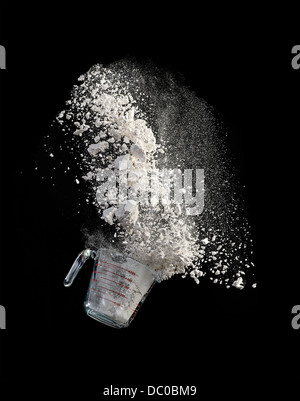 Measuring Cup Falling With Flour Spilling Out Stock Photo - Alamy