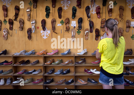 Woman selling leather sandals shoes on a pavement in a Gaborone mall ...