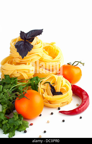 Raw spaghetti noodle with tomatoes and basil isolated in white ...
