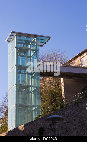 A Modern Outdoor Glass Elevator With A Bridge In Front Of A Bright Blue ...