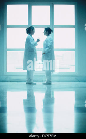 Profile of two female nurses talking to each other Stock Photo - Alamy